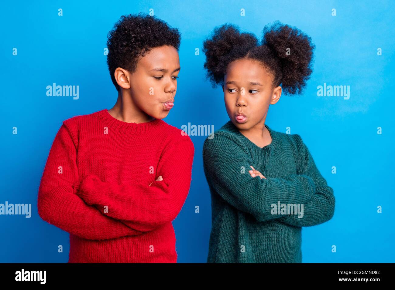 Photo of moody angry dark skin children wear pullovers arms crossed ...