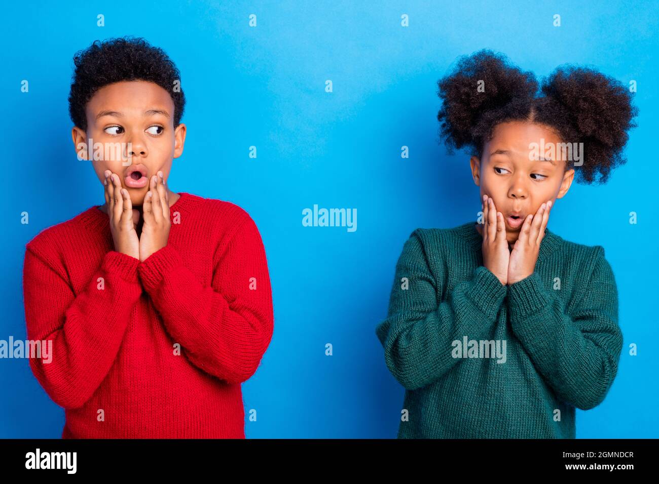 Photo of shocked impressed dark skin kids dressed sweaters hands arms ...
