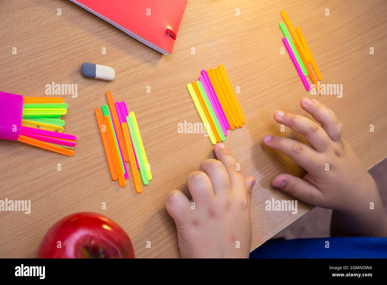 Close-up hands of the student are counted as multi-colored sticks. A ...