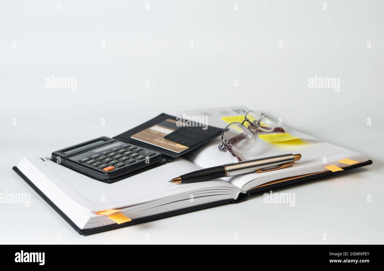 Diary, glasses, calculator, credit card and pen on a white background ...