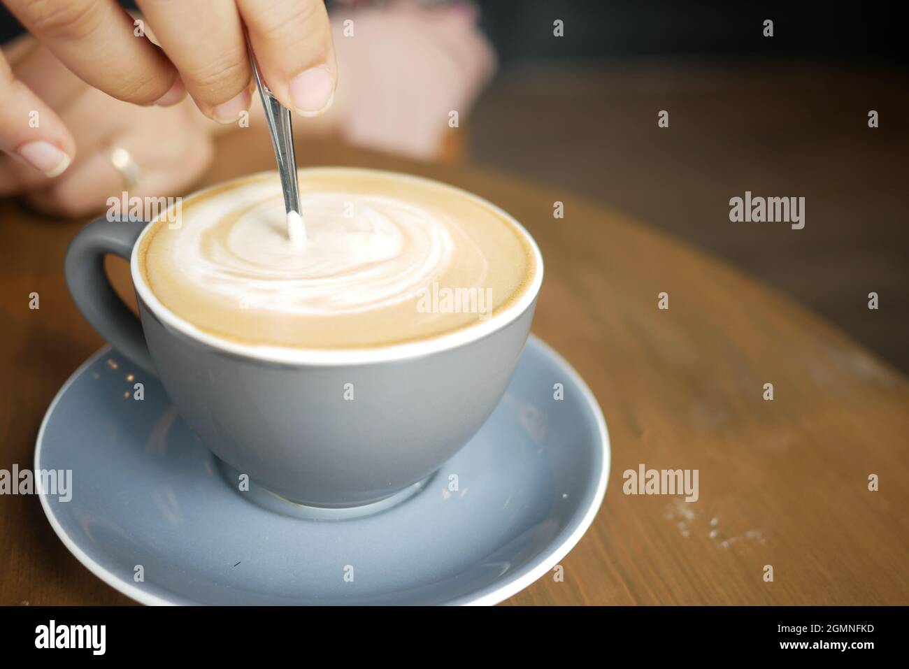 person hand stirring coffee with spoon Stock Photo - Alamy
