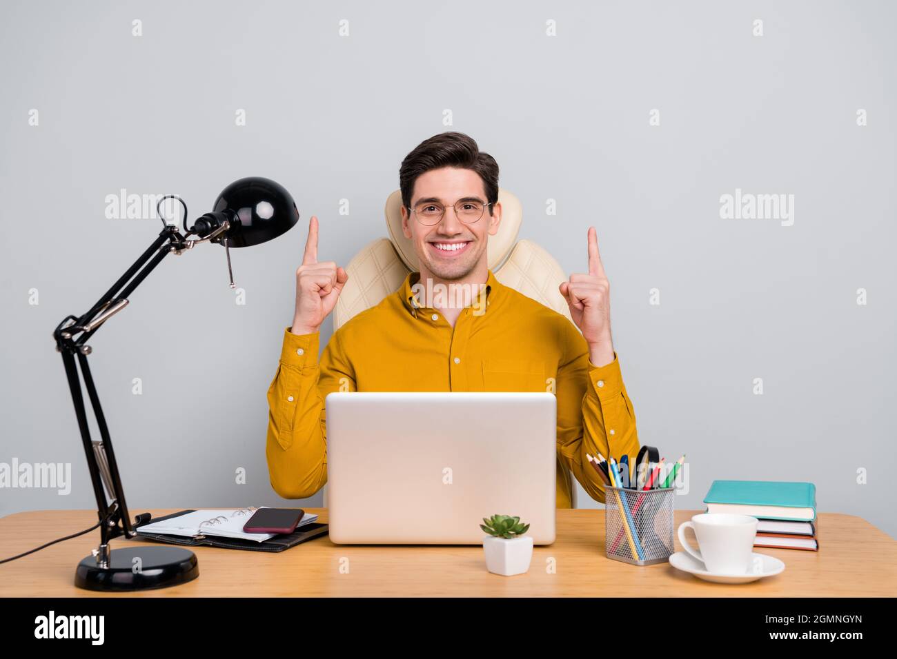Portrait of attractive cheerful man programmer pointing up copy blank ...
