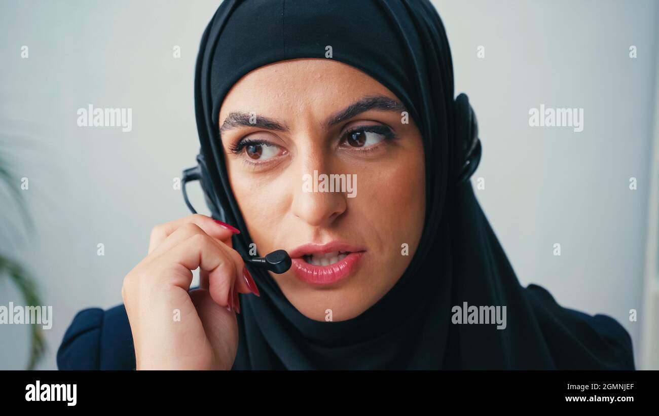 woman in hijab using microphone while talking in call center Stock ...