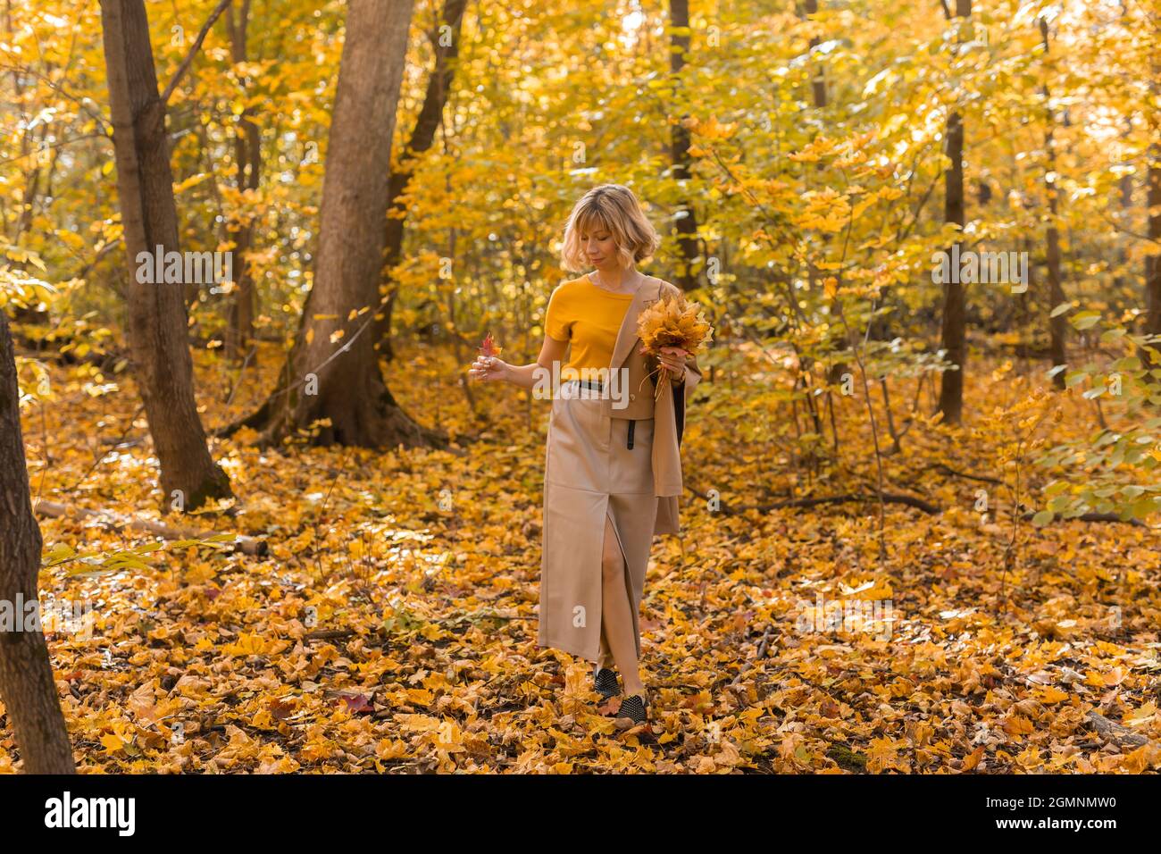 Portrait of beautiful young woman walking outdoors in autumn. Fall ...