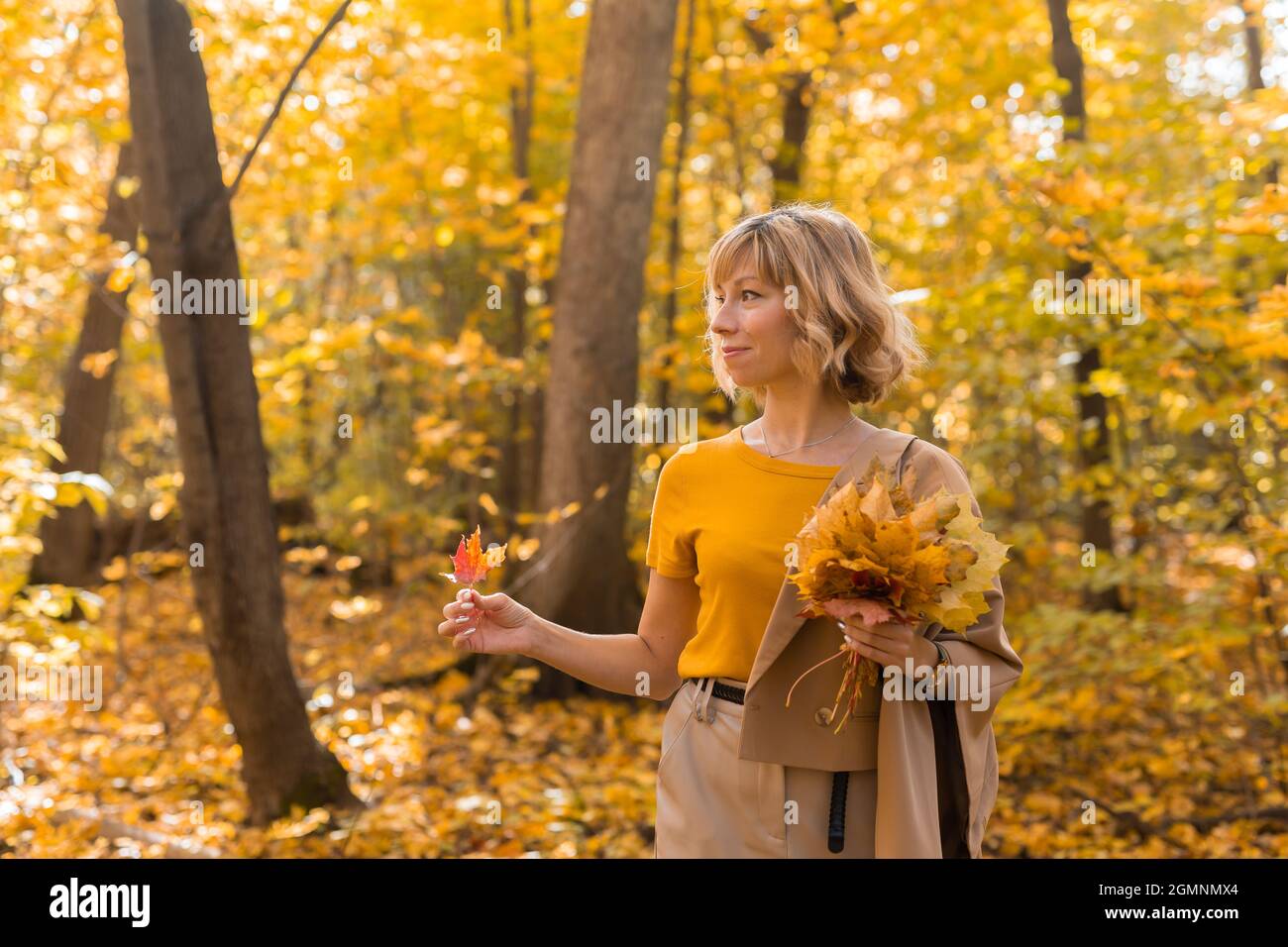 Portrait of beautiful young woman walking outdoors in autumn. Fall ...