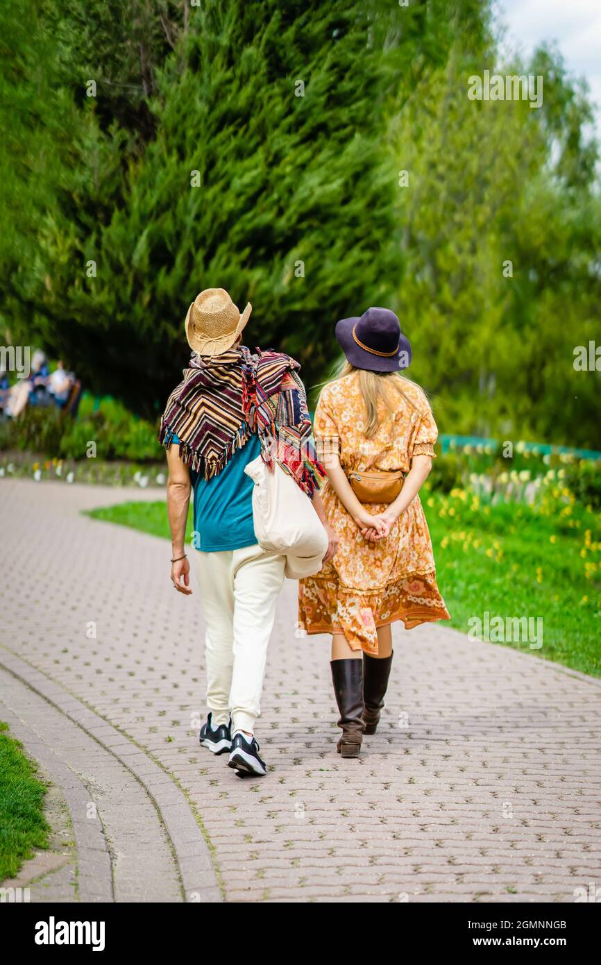 Unrecognizable girl and guy walking together in park. Concept of modern ...