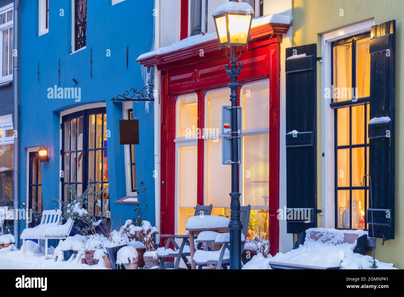 Sunset winter view of snow covered historic houses in the Dutch city ...