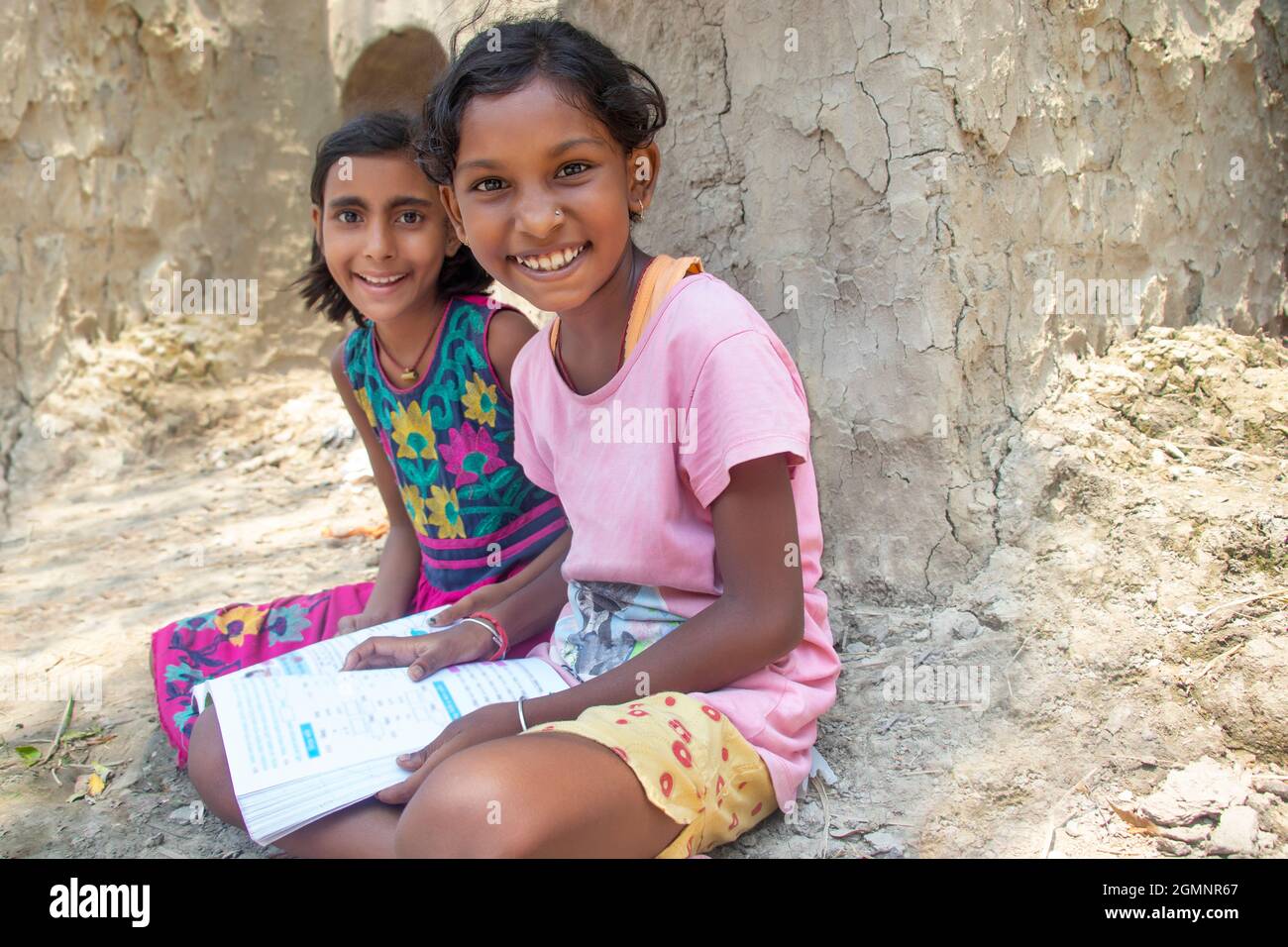 Two Indian rural girls reading book at home Stock Photo - Alamy