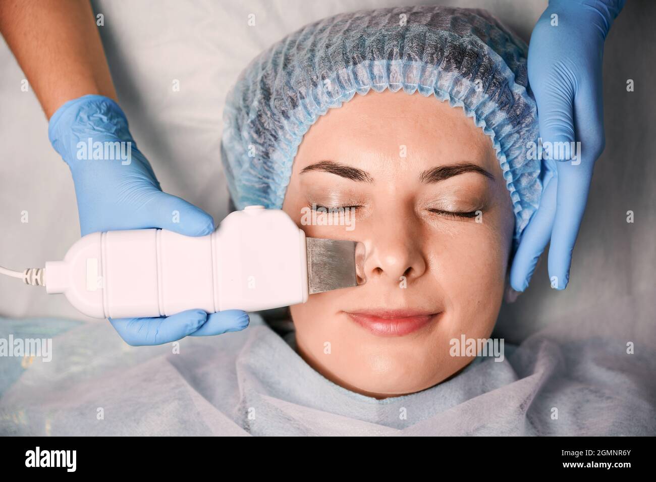 Close up of beautician hands using ultrasonic scrubber while cleaning ...