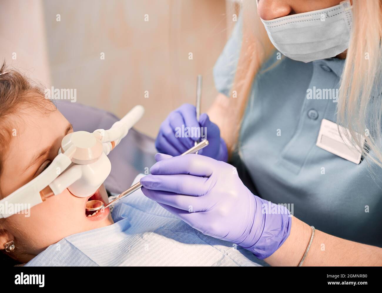 Female dentist checking child teeth with dental explorer and mirror ...