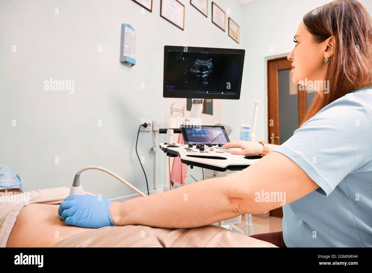 Sonographer doing ultrasound scanning procedure for young woman in ...