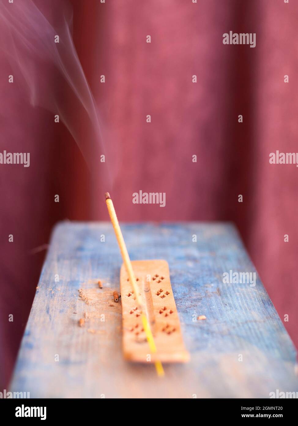 incense stick lit with smoke thread with dark background on light sky ...
