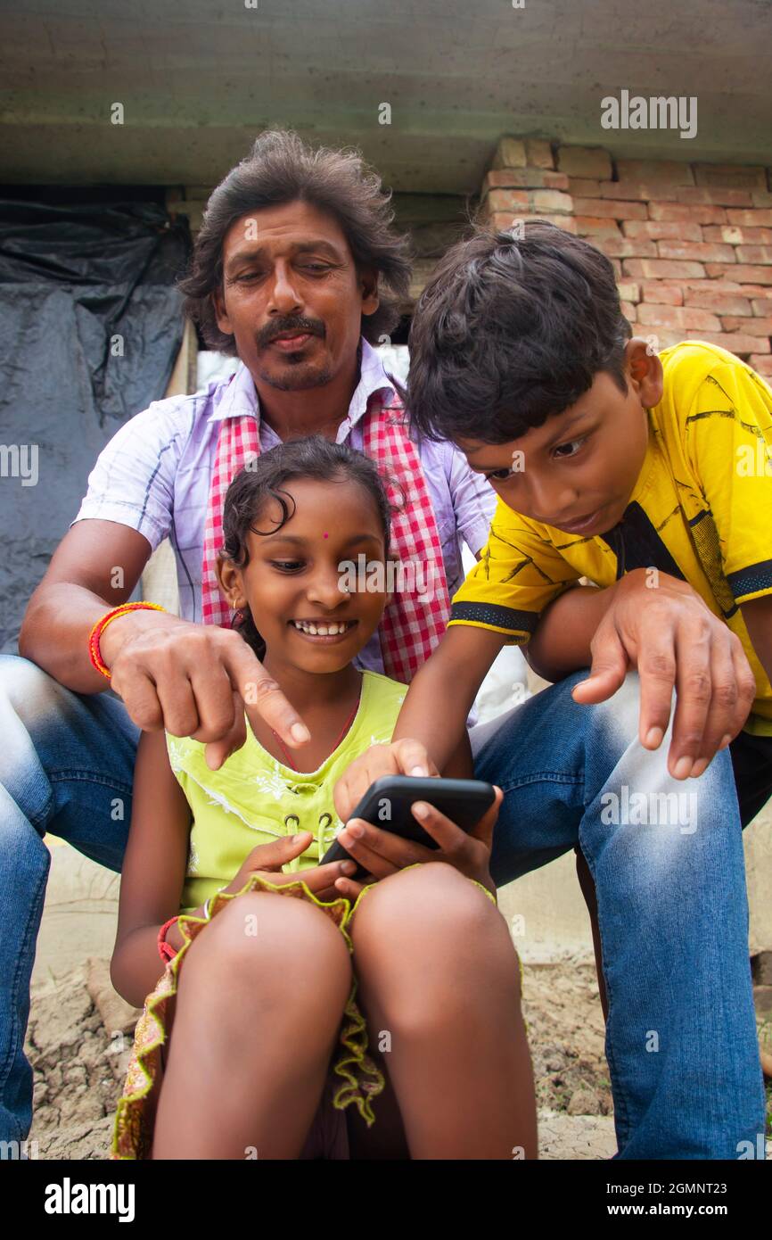 Indian Rural Parent and their two children using mobile phone Stock ...