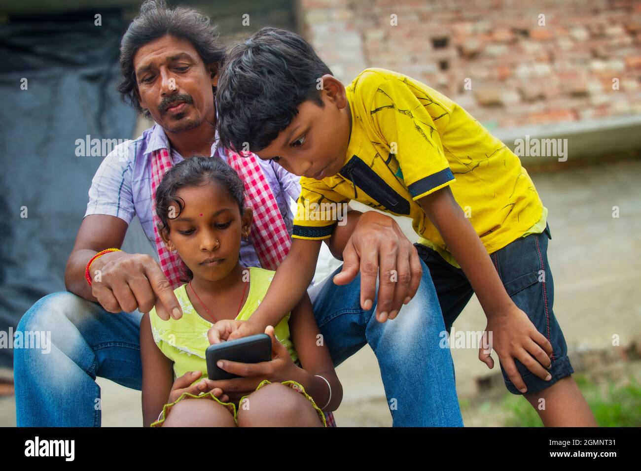 Indian Rural Parent and their two children using mobile phone Stock ...