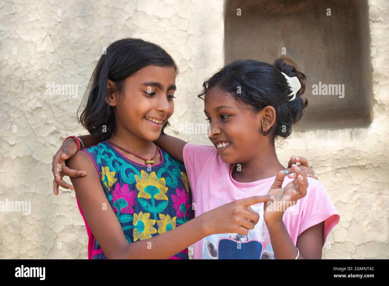 Cheerful two rural girls holding hand while playing at home Stock Photo ...