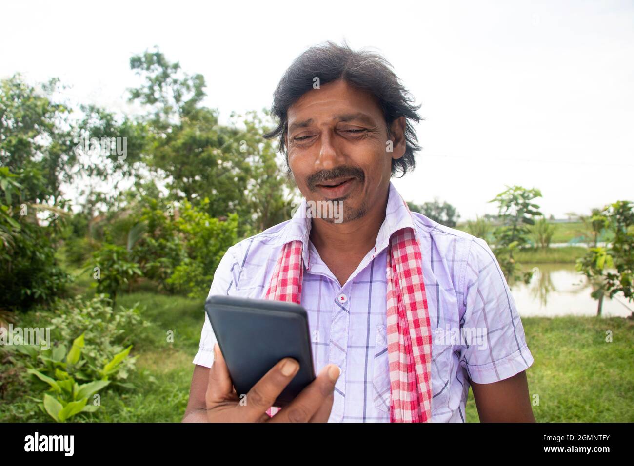 Indian Rural Man Holding mobile phone in agricultural field Stock Photo ...