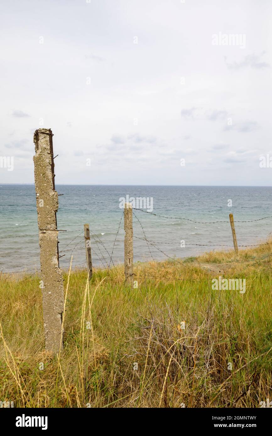 Reinforced concrete posts with stretched old barbed wire. View of the ...