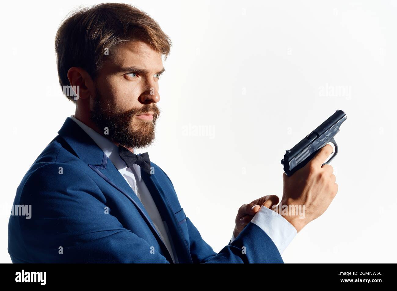 male gangster with a gun in hand Studio emotions Stock Photo - Alamy