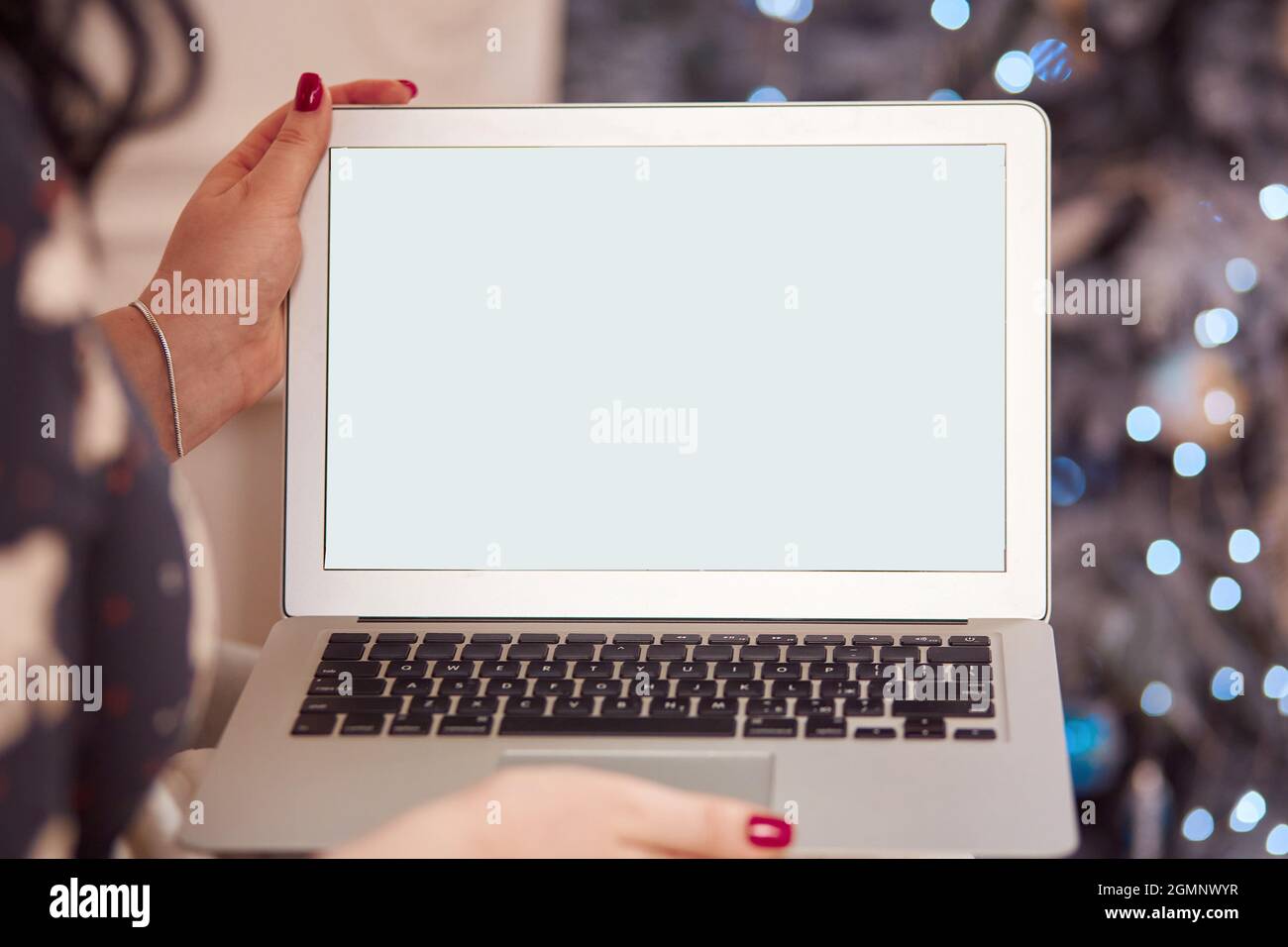 Woman is typing on laptop keyboard. White screen of notebook close up ...