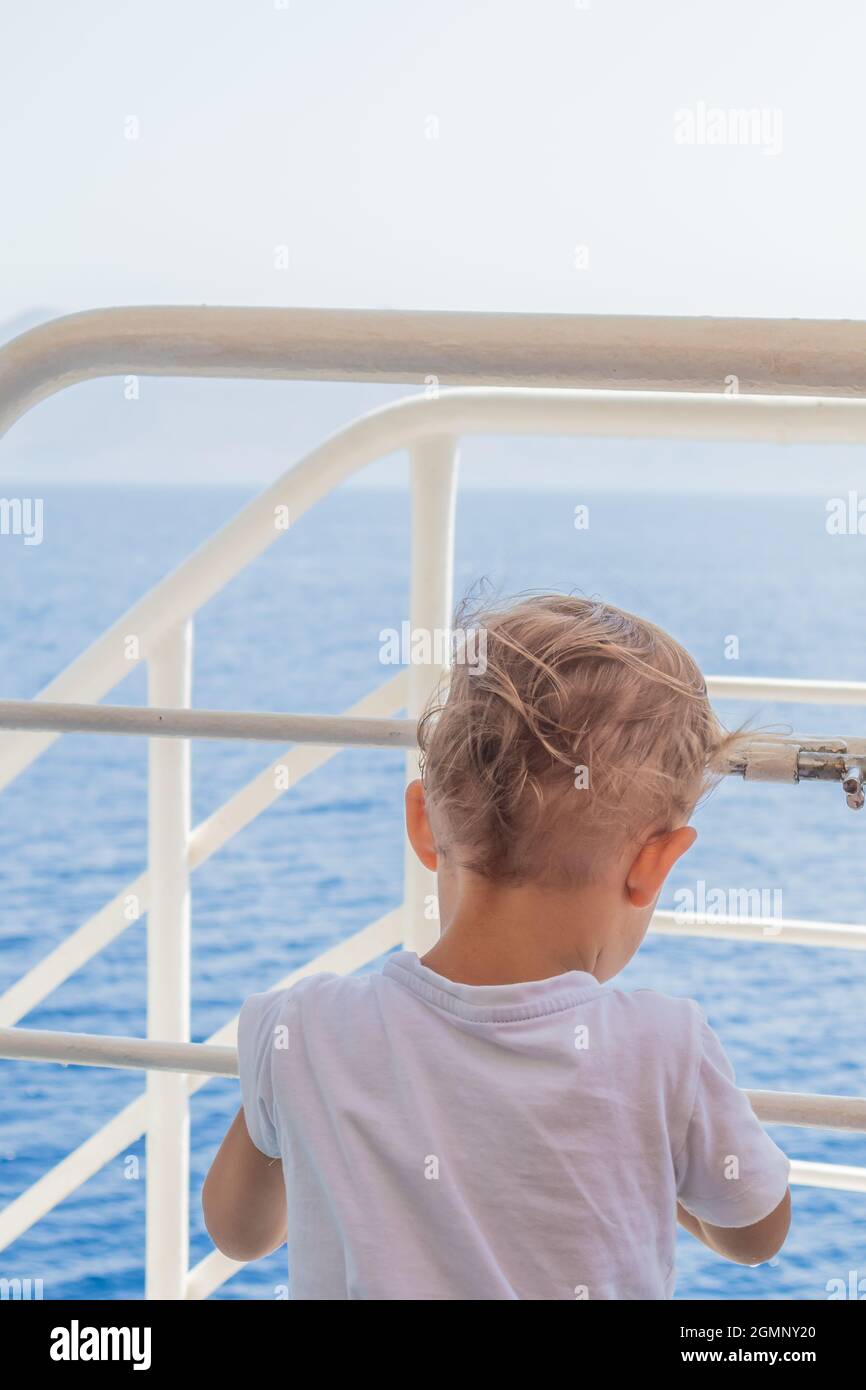 Vertical shot from the back of a cute and beautiful boy child looking ...