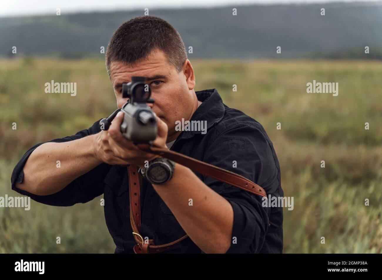 Portrait of a shooter with a rifle. European shoots a rifle with a ...