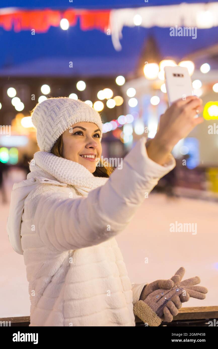 Christmas, winter, technology and leisure concept - happy young woman ...