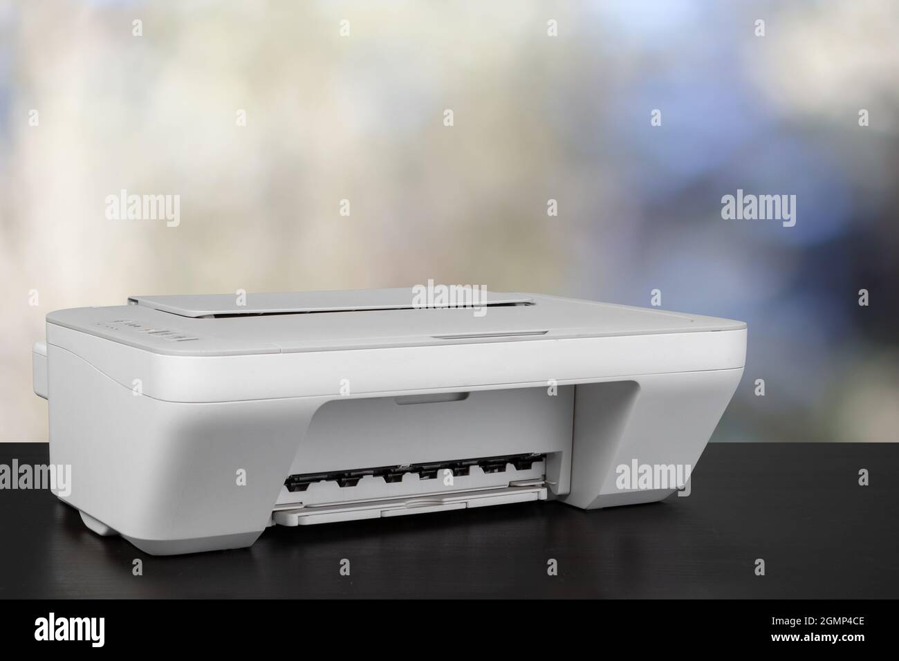 Compact laser printer on black desk against blurred background Stock ...