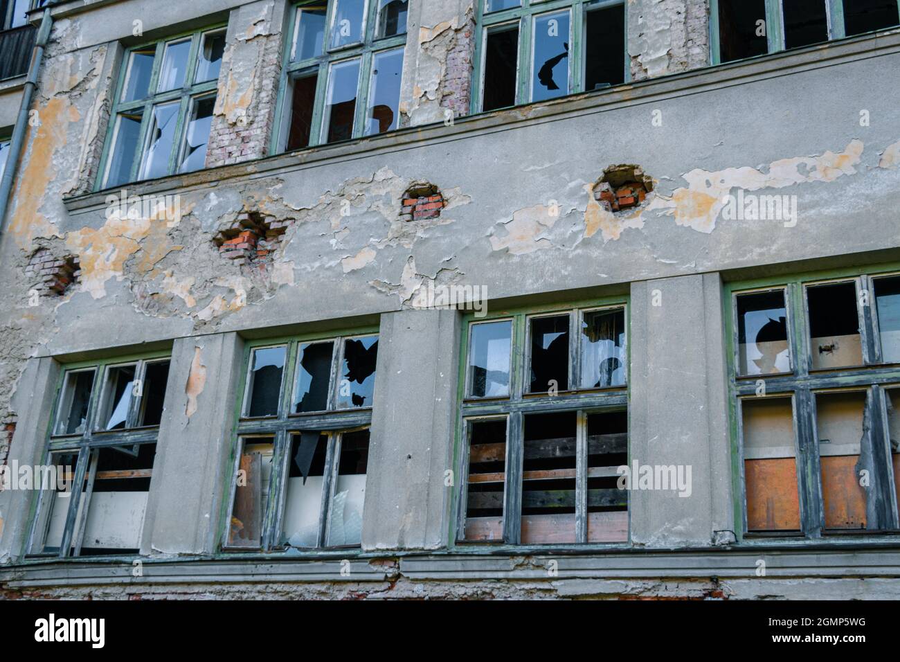 view of an old demolished building and smashed windows with broken ...