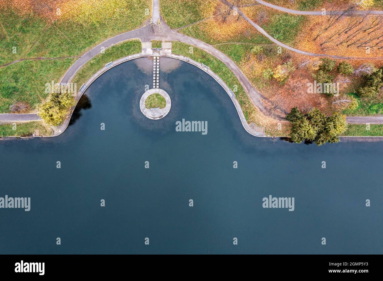 autumn landscape of city park with walking paths near water canal ...