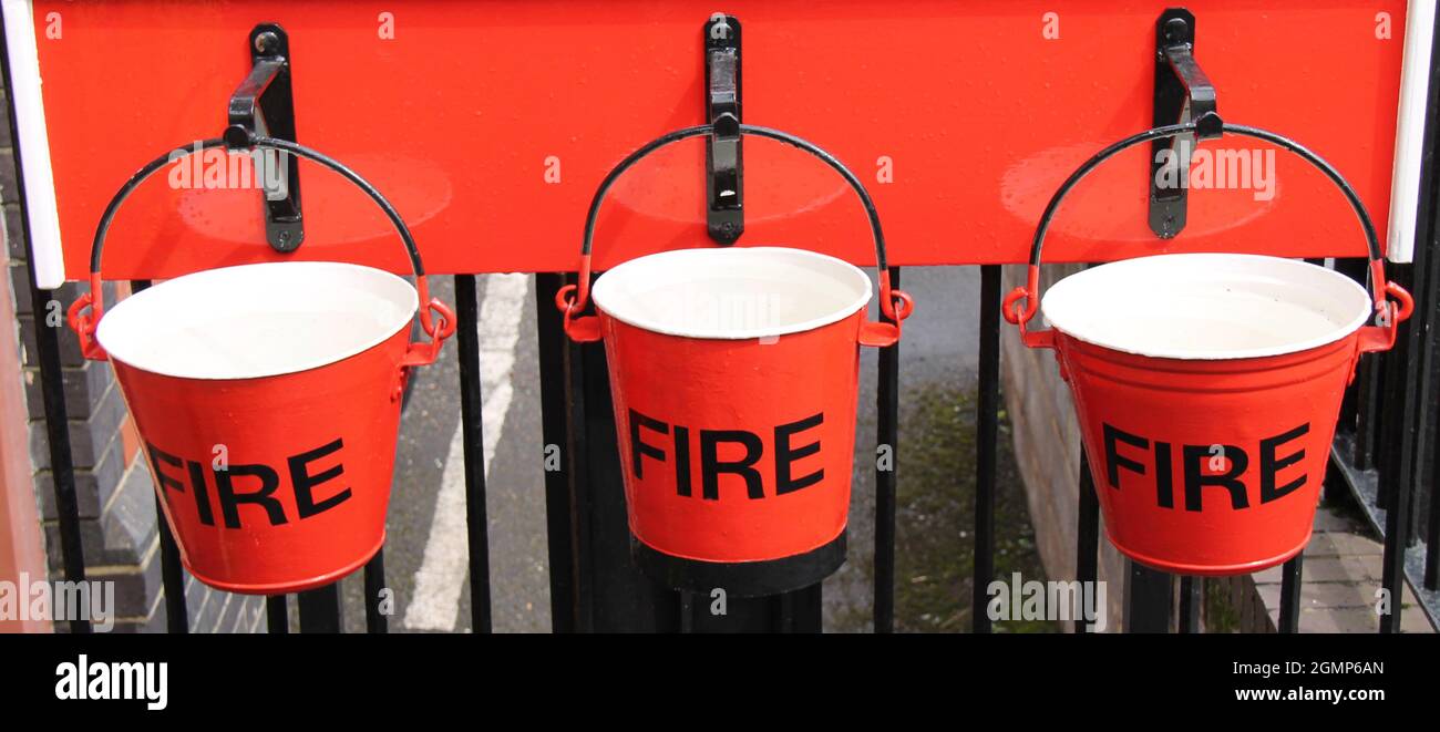 Three Traditional Fire Buckets Hanging in a Row Stock Photo - Alamy