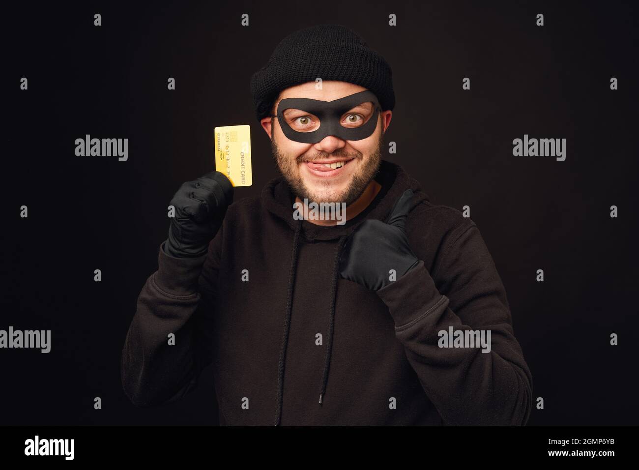 Funny thief holding credit card Stock Photo - Alamy