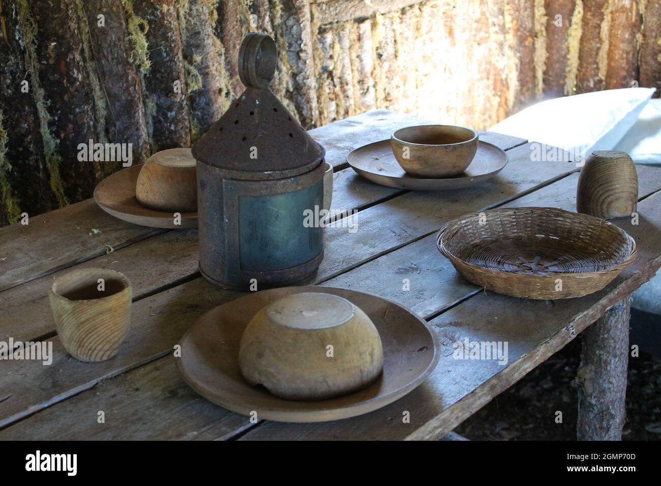 An old-fashioned table setting with wooden bowls, plates, and cups, and ...