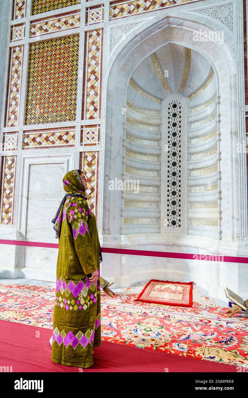 A woman dressed in a traditional omani abaya looking at an ornate ...