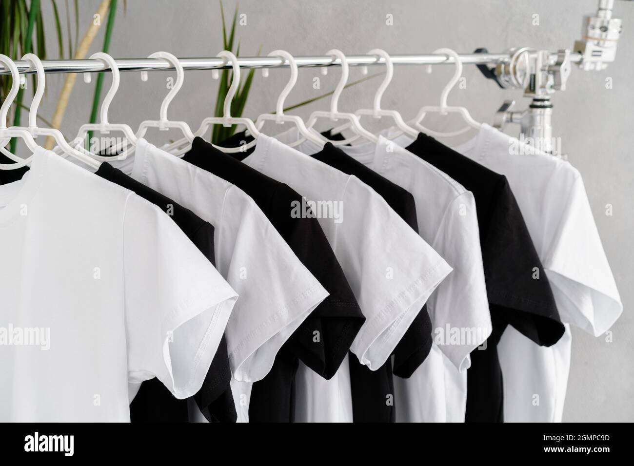 Row of black and white t-shirts hanging on rack Stock Photo - Alamy