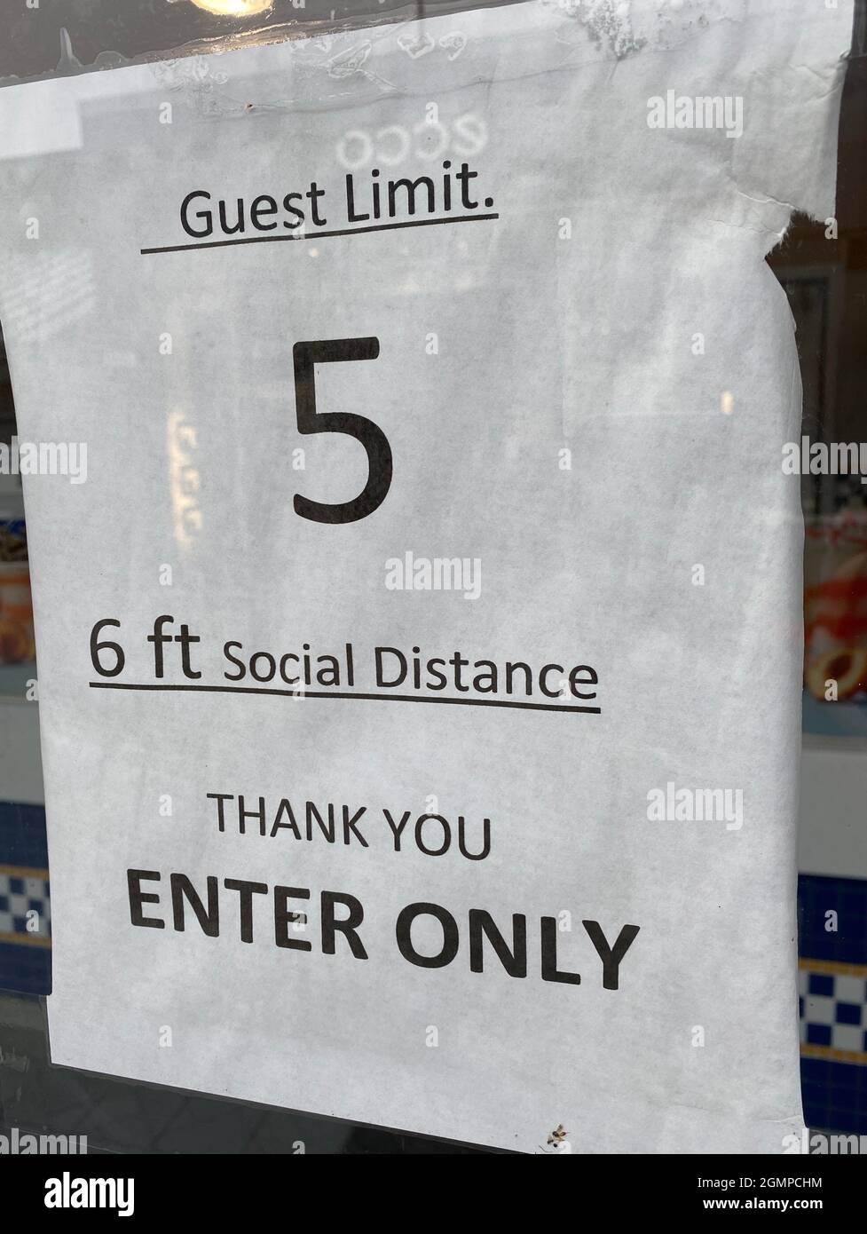 Maximum capacity or guest limit signs at a small store during the ...
