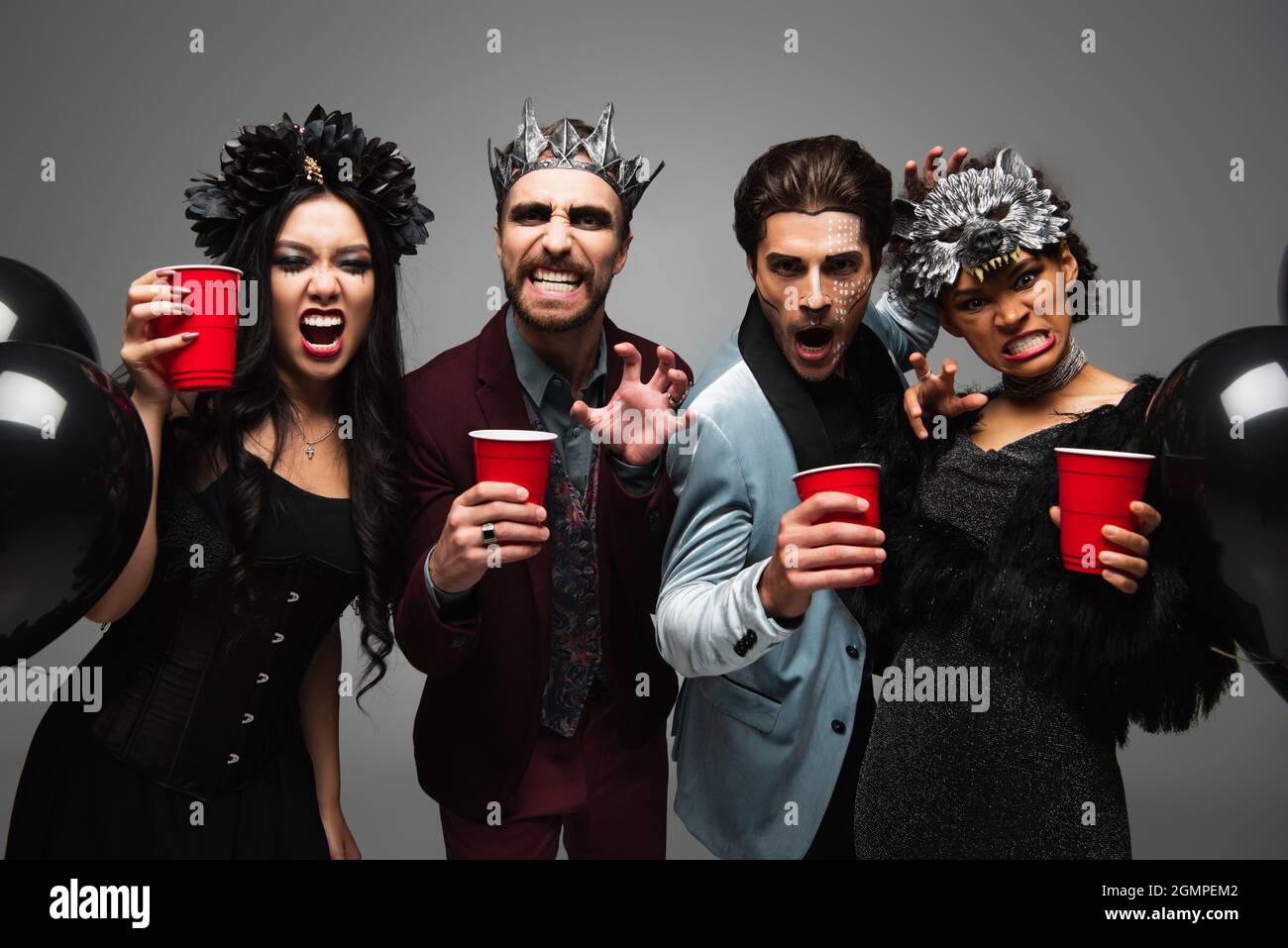 spooky multiethnic friends with plastic cups growling and showing scary ...