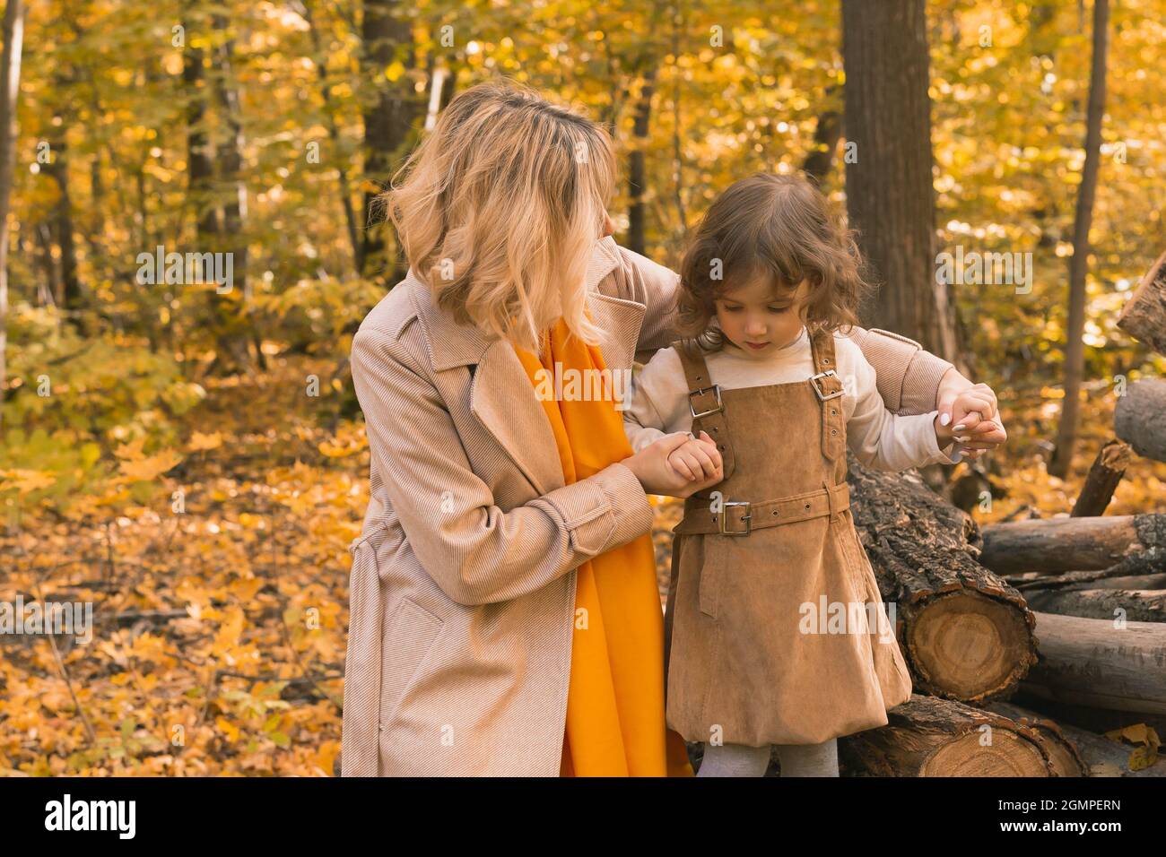 Young mother with her little daughter in an autumn park. Fall season ...
