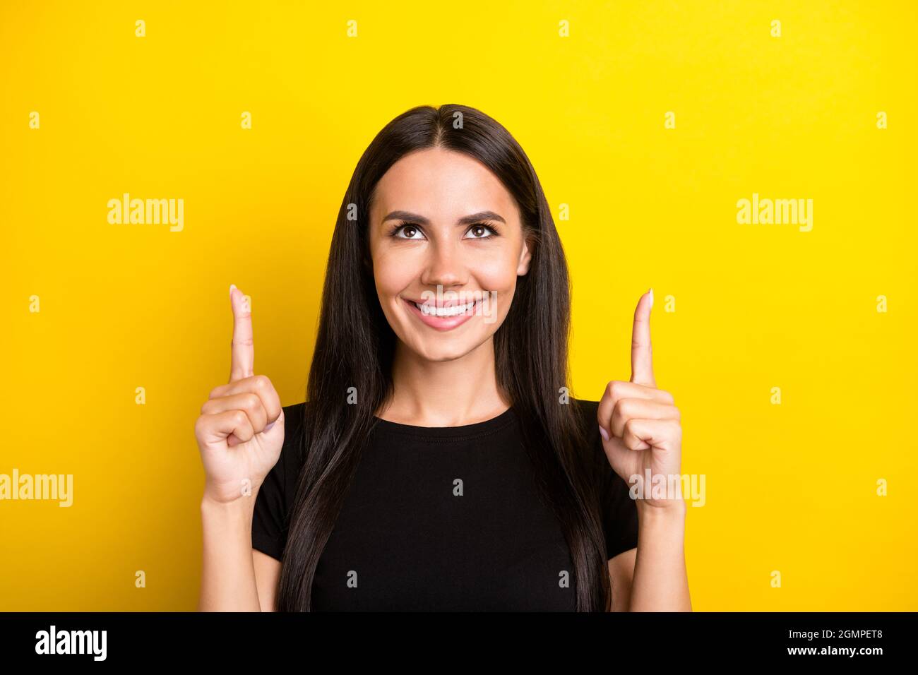 Photo of pretty lady look up indicate fingers empty space toothy smile ...