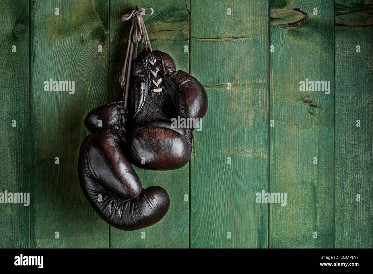 old boxing gloves hanging in front of rustic wooden wall Stock Photo ...