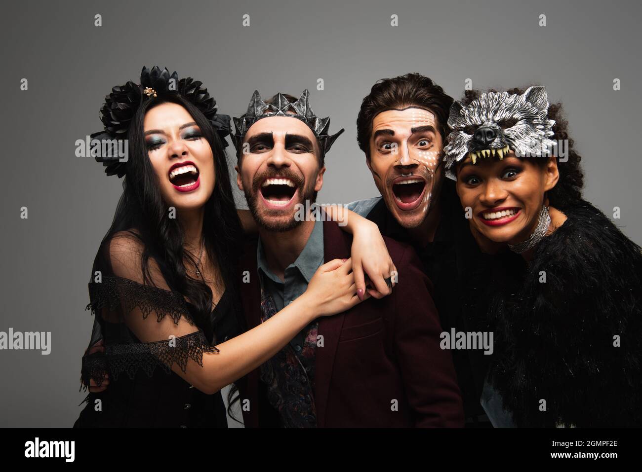 cheerful african american woman hugging man in vampire king crown ...