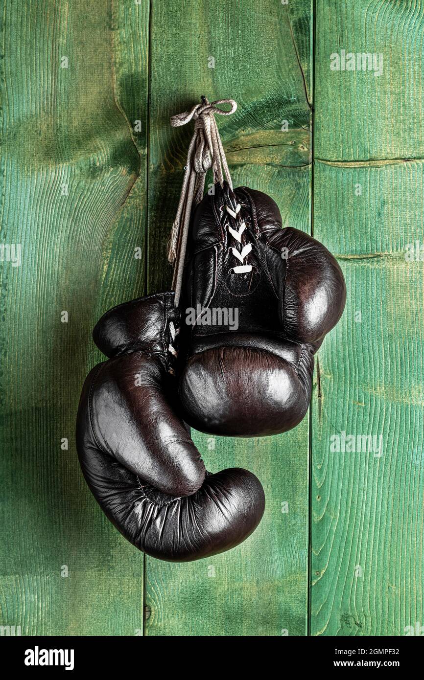 old boxing gloves hanging in front of rustic wooden wall Stock Photo ...