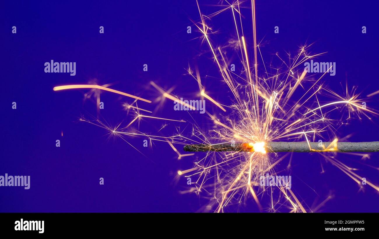 Burning bengal fire on blue background Stock Photo - Alamy