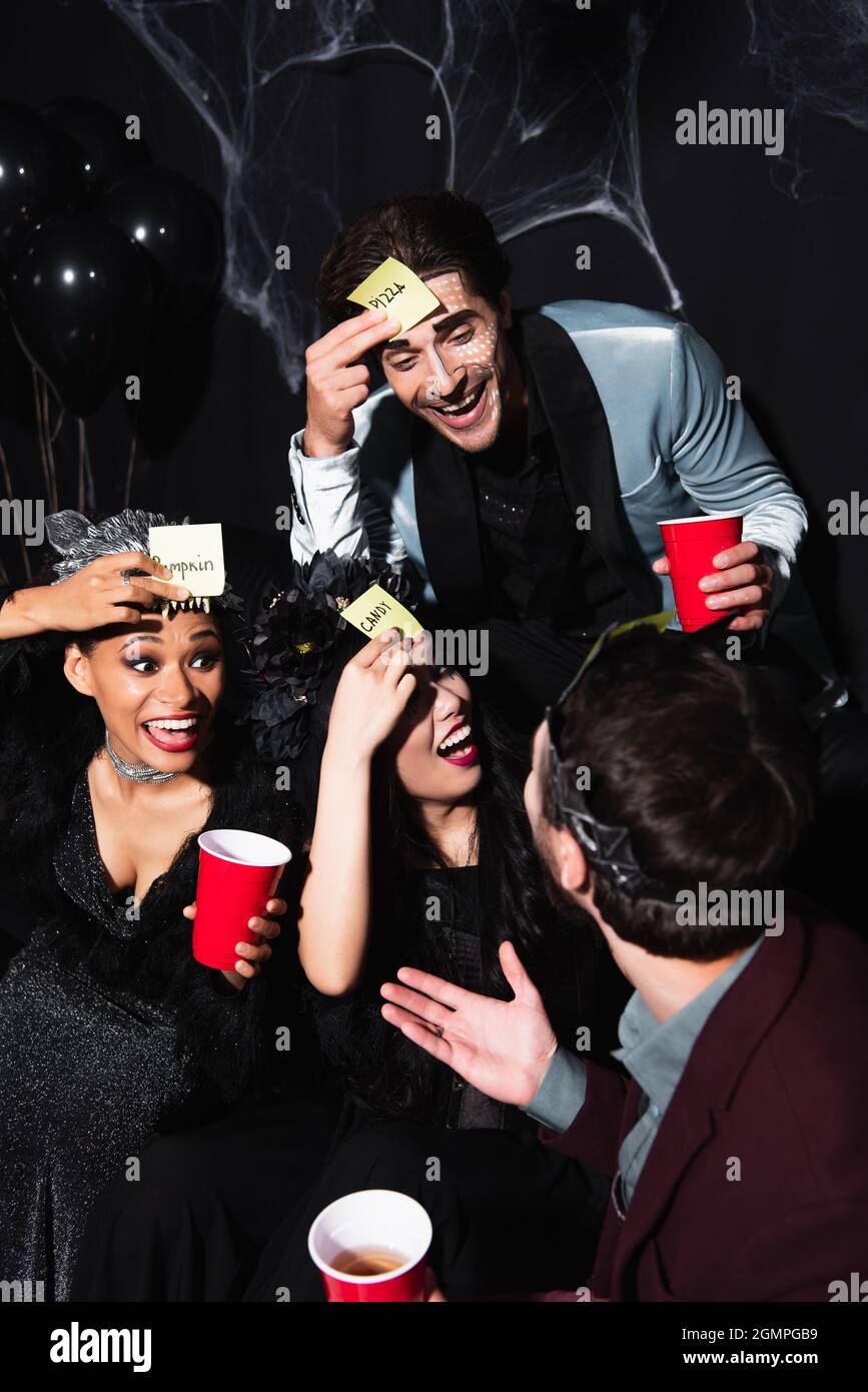 high angle view of man pointing with hand near multiethnic friends ...