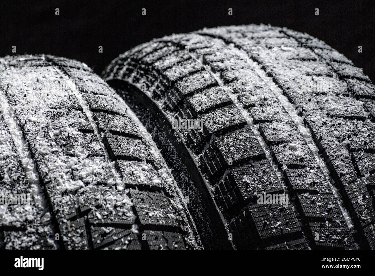 Winter Car tires with snow close-up wheel profile structure on black background Stock Photo - Alamy