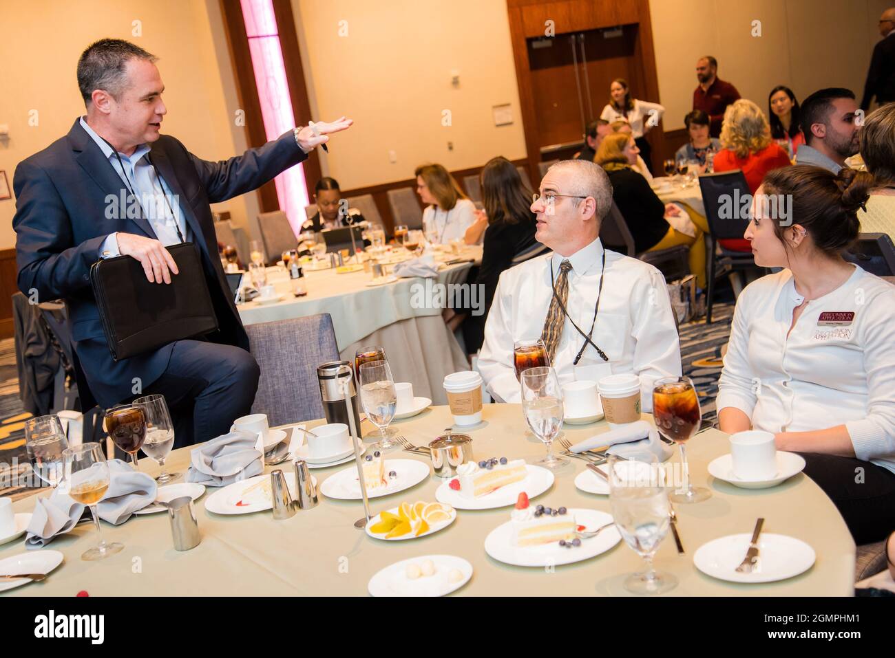 A male CEO talks and gestures while his colleagues listen Stock Photo ...
