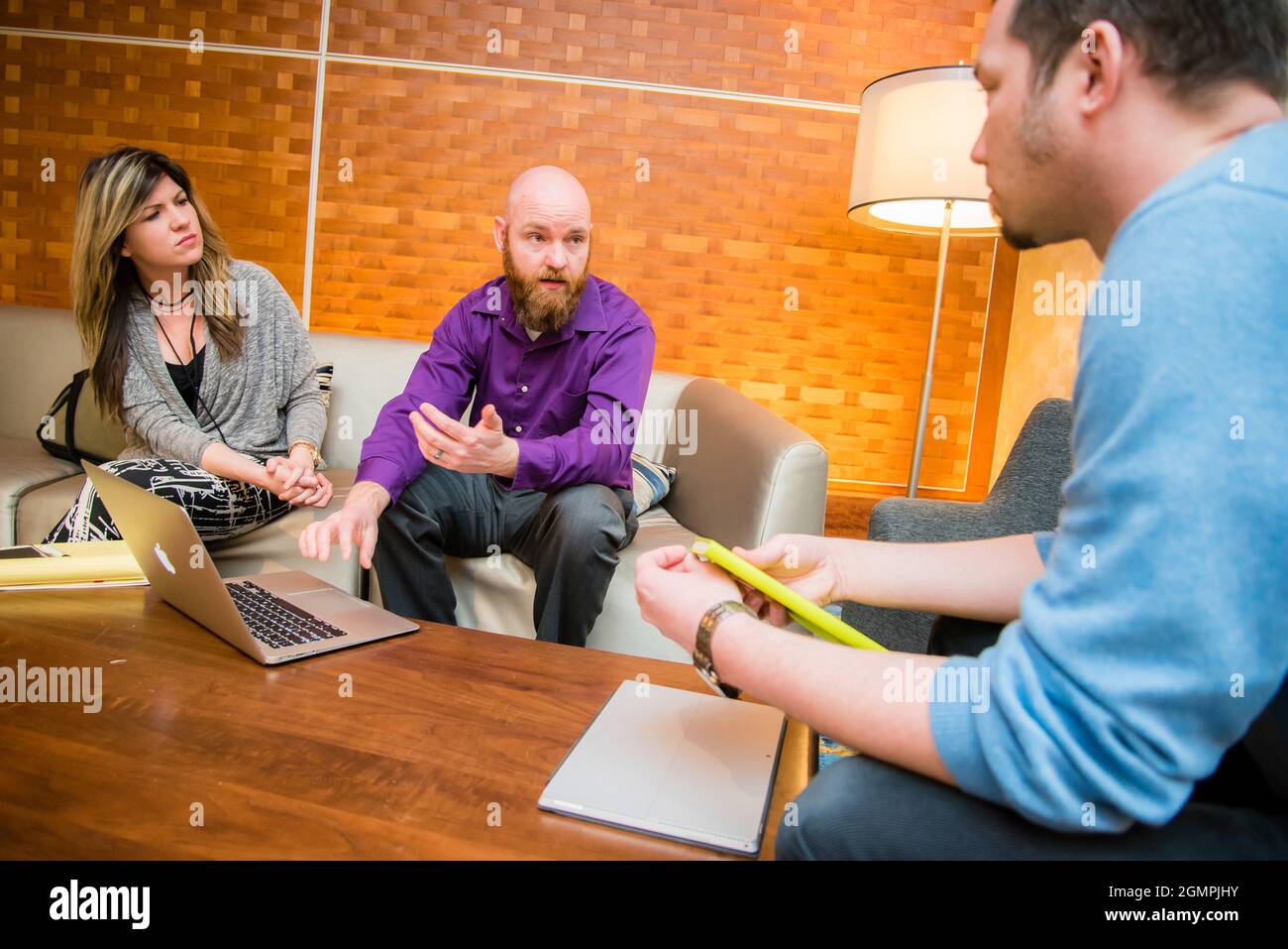 Small group of adult professionals collaborating around coffee table ...