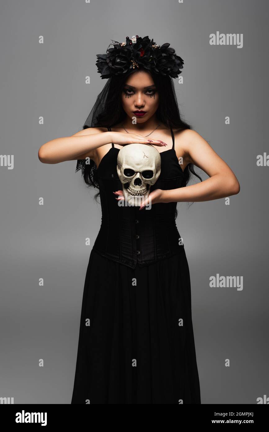 asian woman in vampire halloween costume holding spooky skull isolated ...