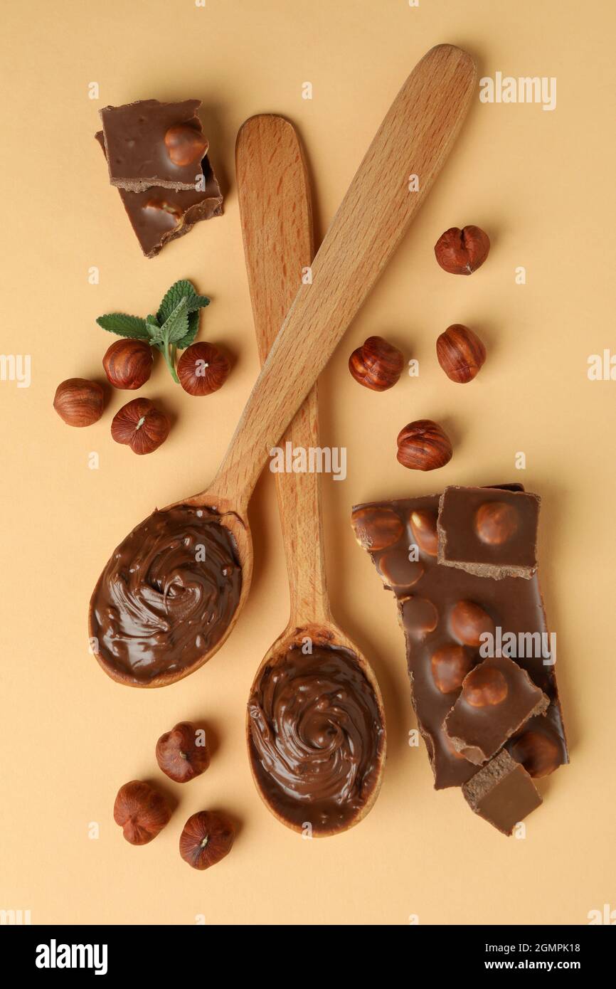 Spoons with chocolate paste, nuts, chocolate and mint on beige ...