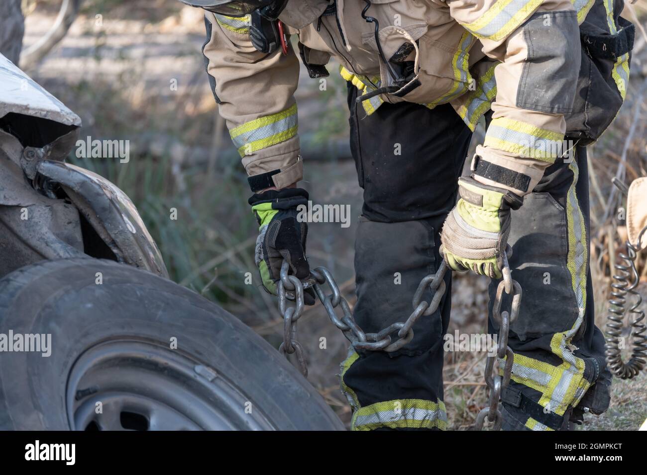 Firefighter rescuing a fallen car in the ditch Stock Photo - Alamy