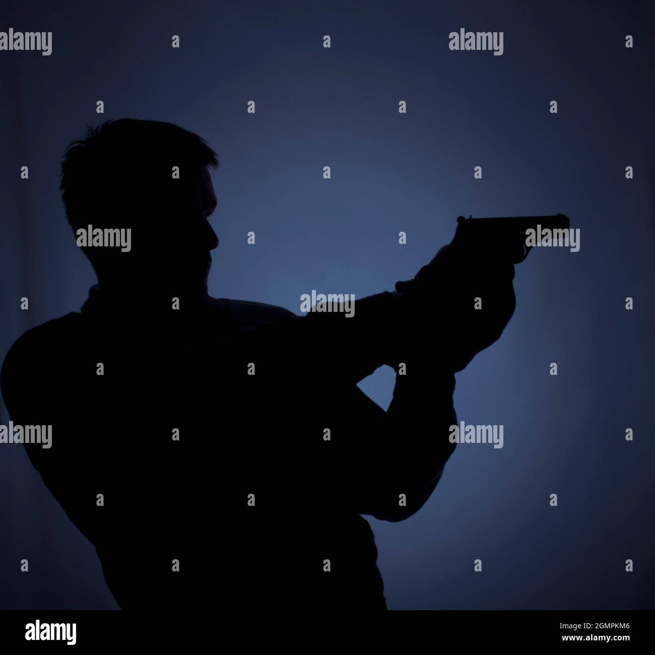 Young man holding a gun Stock Photo - Alamy